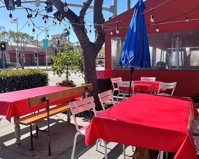 Al fresco dining with vibrant red tablecloths under string lights. California sunshine and fried chicken—a match made in culinary heaven.