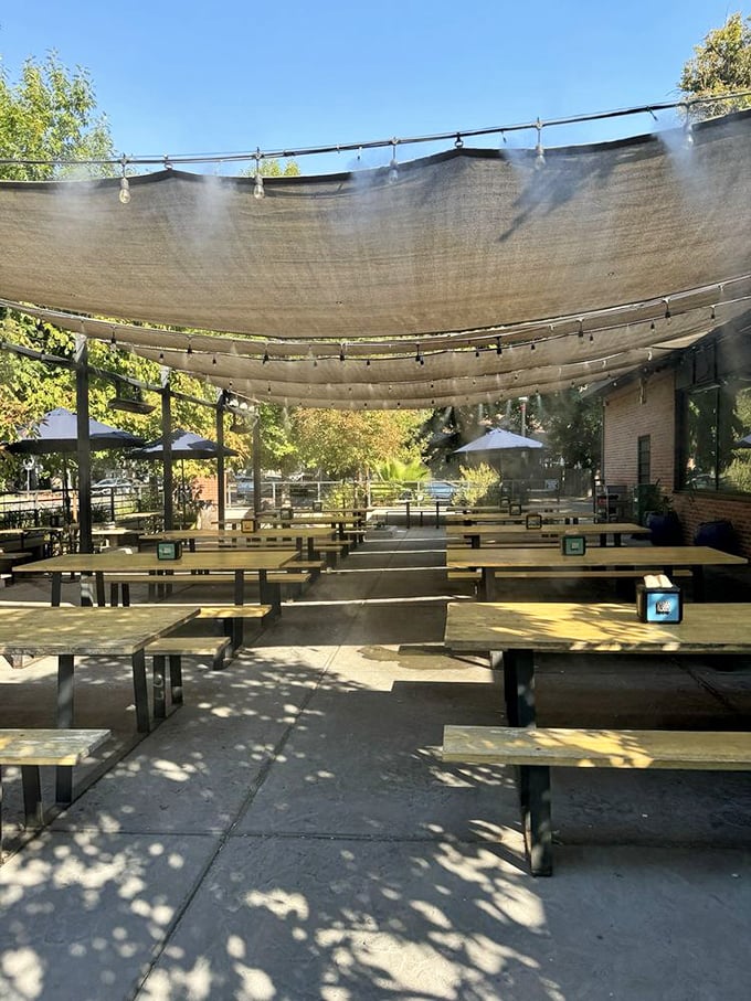 The outdoor patio, shaded and inviting, where picnic tables await under string lights – barbecue's natural habitat.