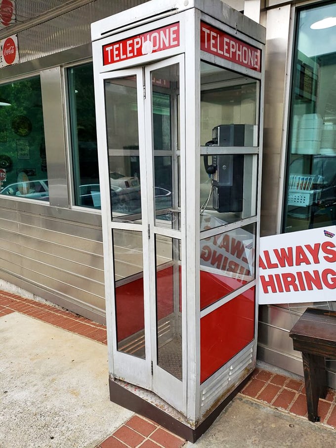 A genuine telephone booth stands guard outside, reminding us of simpler times before smartphones ruled.