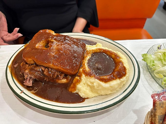 A hot open-faced sandwich drowning in rich gravy – the kind of hearty meal that fueled generations of farmers and still satisfies modern appetites.