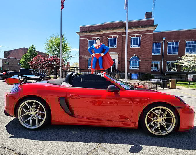 Some visitors coordinate their vehicles with Superman's color scheme—this red sports car owner clearly understood the assignment.