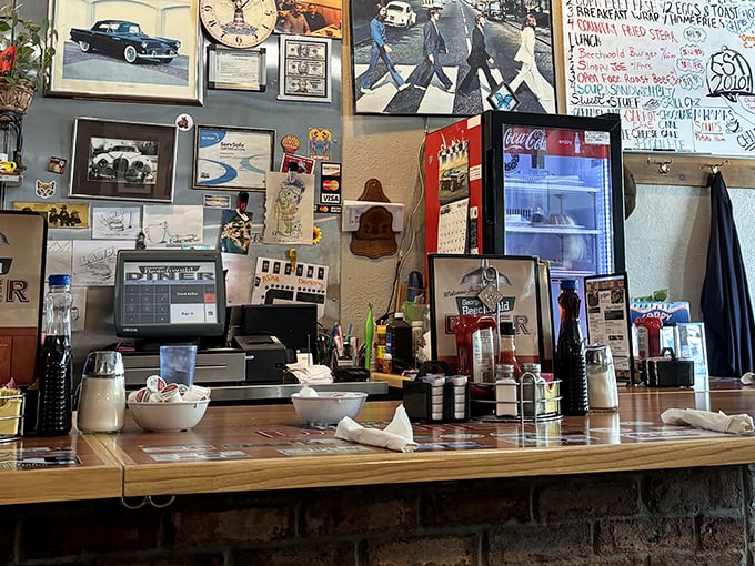 The command center where Beatles album covers meet order tickets, creating a time capsule of American diner culture that feels like coming home.