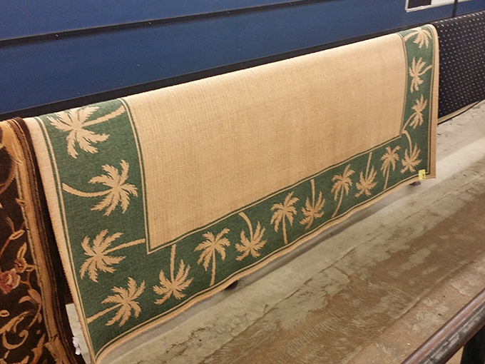 Florida meets function—a palm-bordered rug that once tied someone's room together now waits for its next supporting role.