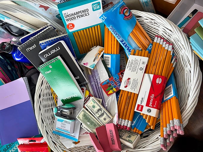 School supplies nestled in a basket like a teacher's dream—pencils, erasers, and even play money for those "real-world math" lessons.