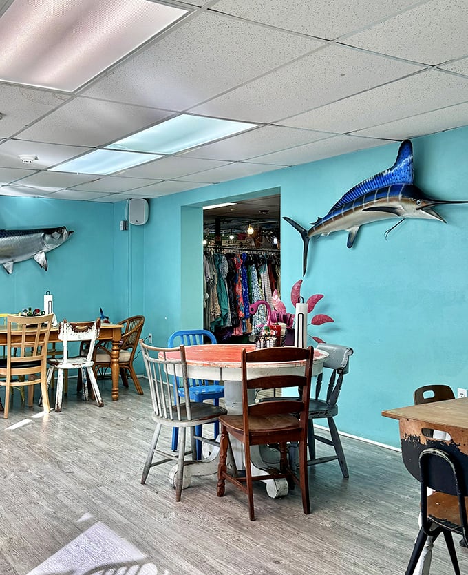 The storefront proudly announces its multiple personalities—bakery, cafe, vintage shop—with colorful chairs standing guard like a rainbow welcoming committee.