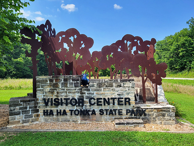 The visitor center sign stands like a rustic welcome mat. Behind it lies adventures that no brochure could possibly oversell.