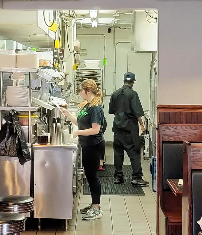 Kitchen choreography in action. The staff moves with the practiced precision of dancers who know the steps by heart.