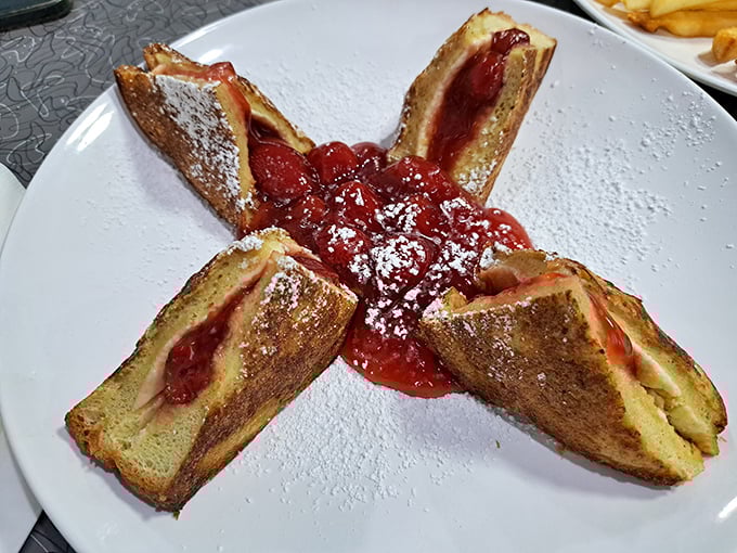 Stuffed French toast arranged like a star, crowned with strawberry topping and powdered sugar – breakfast that doubles as edible art.