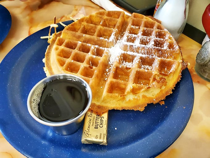 This golden waffle isn't just breakfast—it's an edible sunbeam, dusted with powdered sugar and served with maple syrup for proper morning bliss.