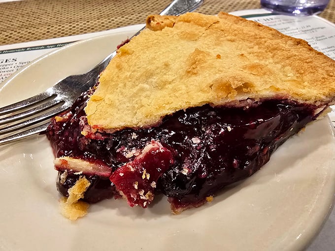 This slice of blueberry pie isn't just dessert—it's a purple-hued miracle with a buttery crust that makes you wonder why anyone bothers with birthday cake.