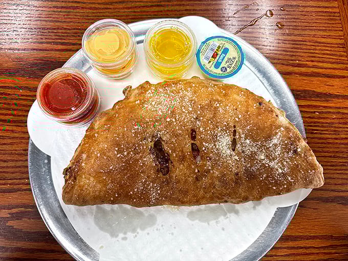 The calzone with dipping sauces – a half-moon of happiness that proves folded pizza might be pizza's perfect final form.