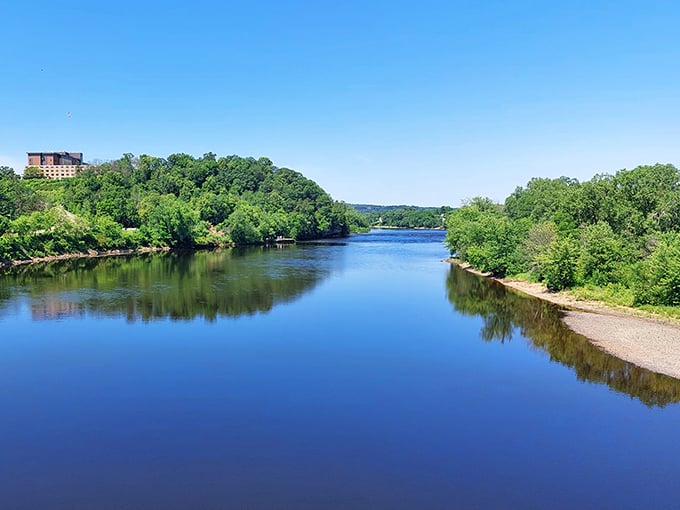 The Chippewa River stretches like a blue ribbon through lush greenery, reflecting sky and forest in its mirror-like surface—nature's perfect selfie.