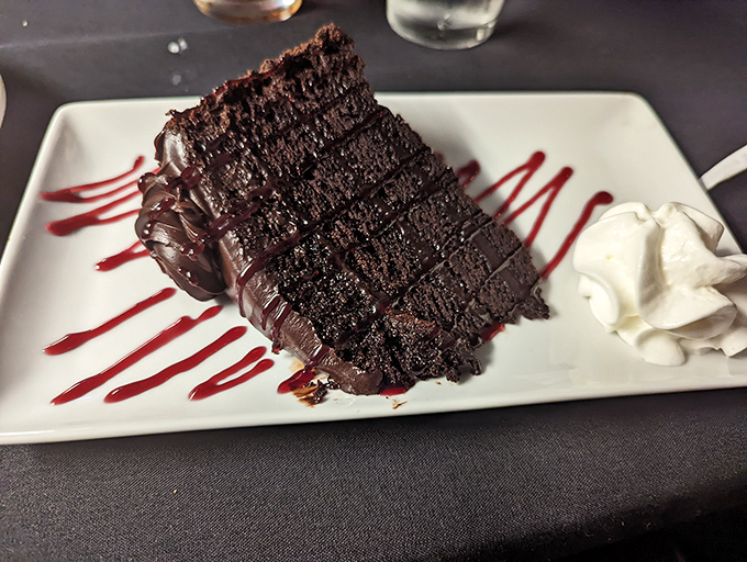 A chocolate cake so rich it should come with its own tax bracket, artfully presented for maximum temptation.