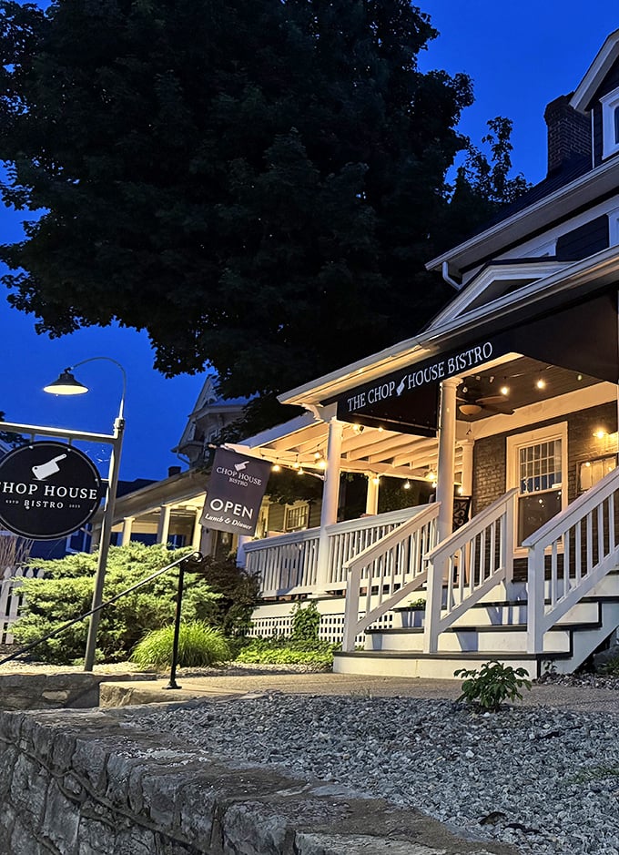 The Chop House Bistro glows with evening promise—where white railings and warm lights invite you to dinner conversations that outlast dessert.