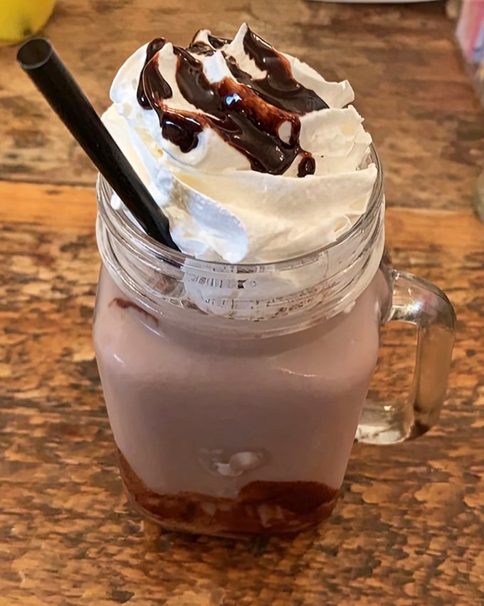 A mason jar milkshake topped with whipped cream and chocolate drizzle that's basically breakfast dessert—and we're not complaining.