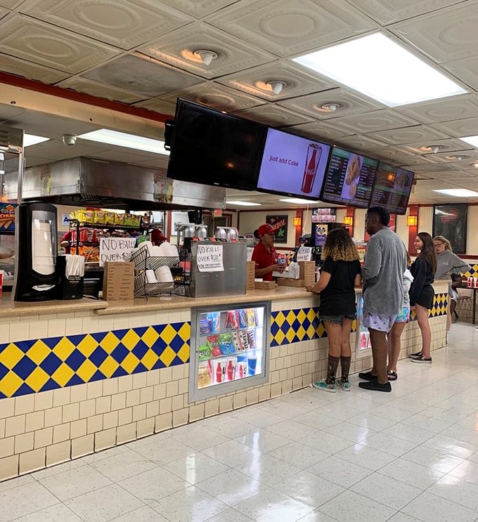 The concession counter where memories are made one nacho at a time—the yellow and blue tiles haven't changed since your parents brought you here.
