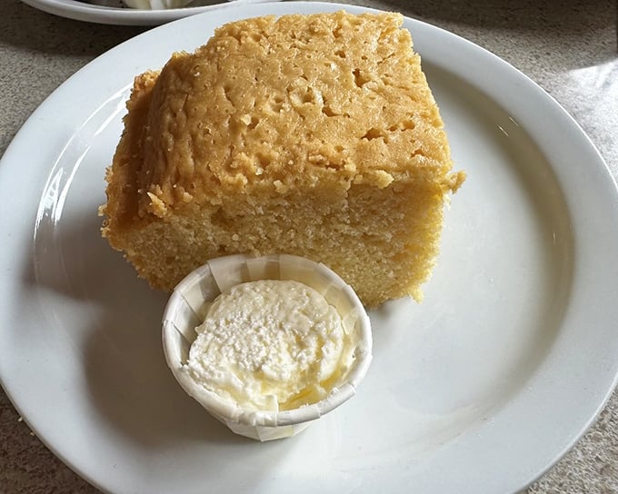 Cornbread that achieves the impossible: simultaneously moist and crumbly. That butter cup isn't just a garnish—it's your new best friend.