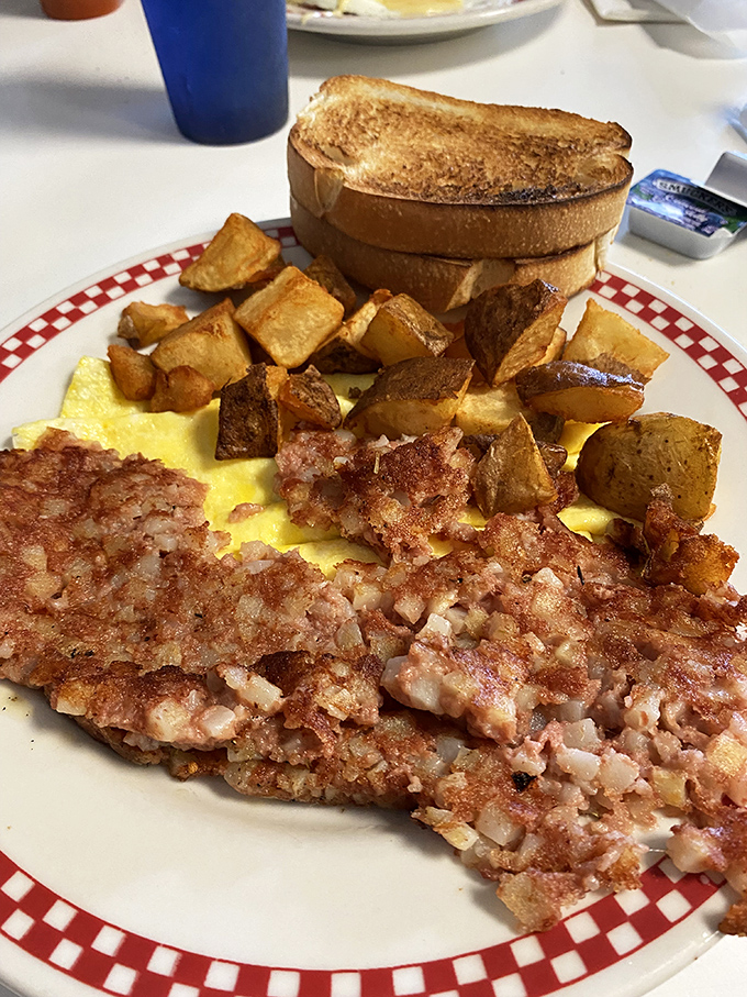 A breakfast plate that means business—crispy home fries, fluffy scrambled eggs, and what appears to be corned beef hash ready to fuel your Erie adventures.