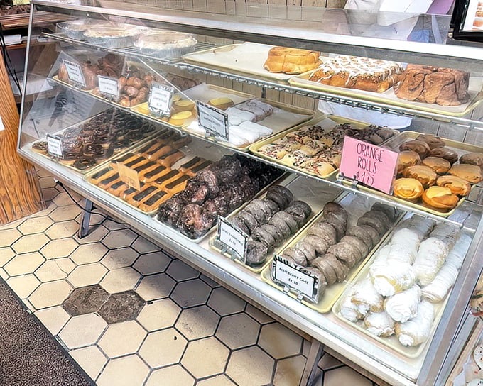 The display case—a glass-fronted gallery where art is measured not in brushstrokes but in sprinkles, glazes, and the occasional strategic drizzle.