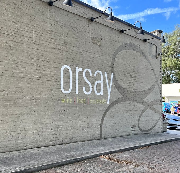 The daytime view of Orsay's exterior wall reveals its understated elegance—wine, food, cocktails—three simple words that promise so much more inside.