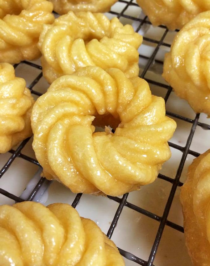 French crullers that defy physics—impossibly light yet substantial, with ridges that capture just the right amount of glaze in every delicate bite.
