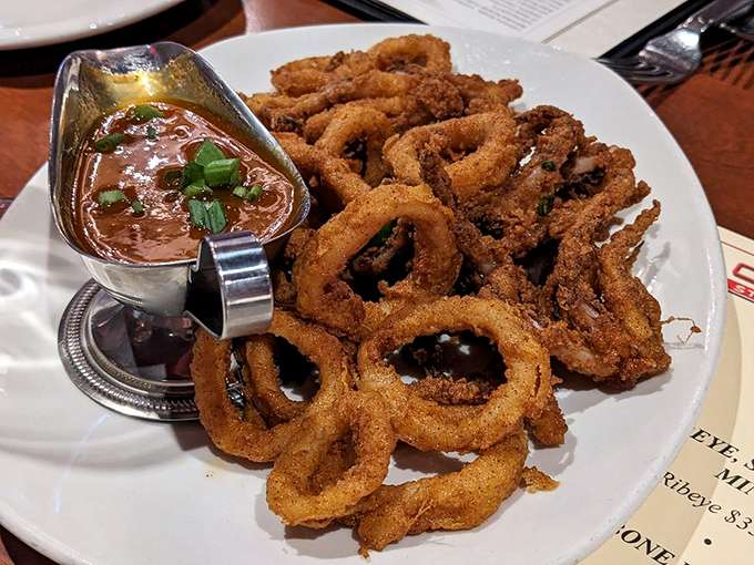 Crispy calamari rings piled high with dipping sauce standing by. The perfect opening act before the main event steals the show.