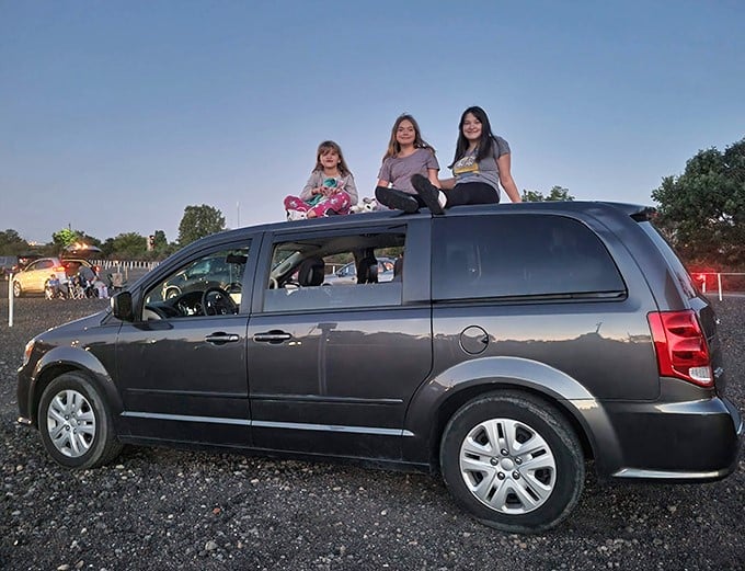 The roof of the family van becomes prime seating for these young moviegoers—creating memories that will outlast whatever's playing on screen tonight.