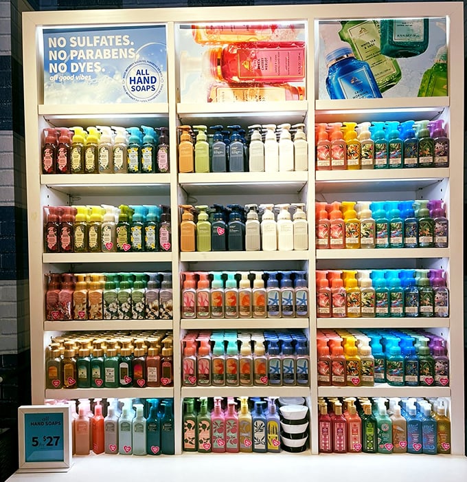 Bath & Body Works' wall of hand soaps – a fragrant color wheel that transforms mundane hand-washing into an aromatherapy session worth lingering over.