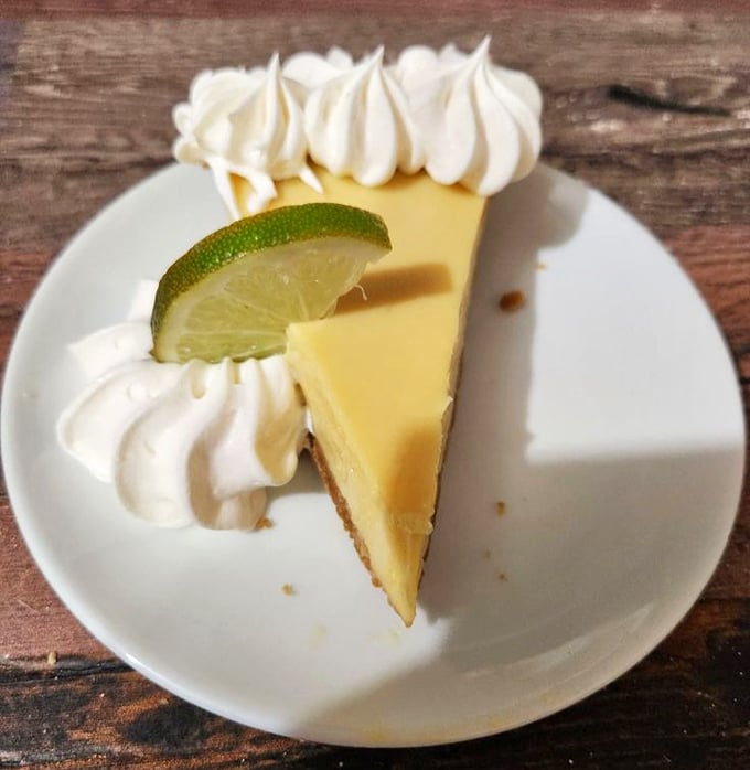 Key lime pie that strikes the perfect balance between sweet and tart – topped with whipped cream clouds and a lime slice exclamation point.