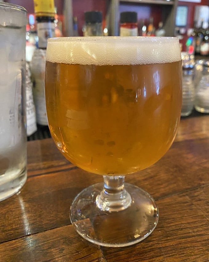 A perfectly poured craft beer catches the light like liquid amber – the ideal companion for your burger adventure.