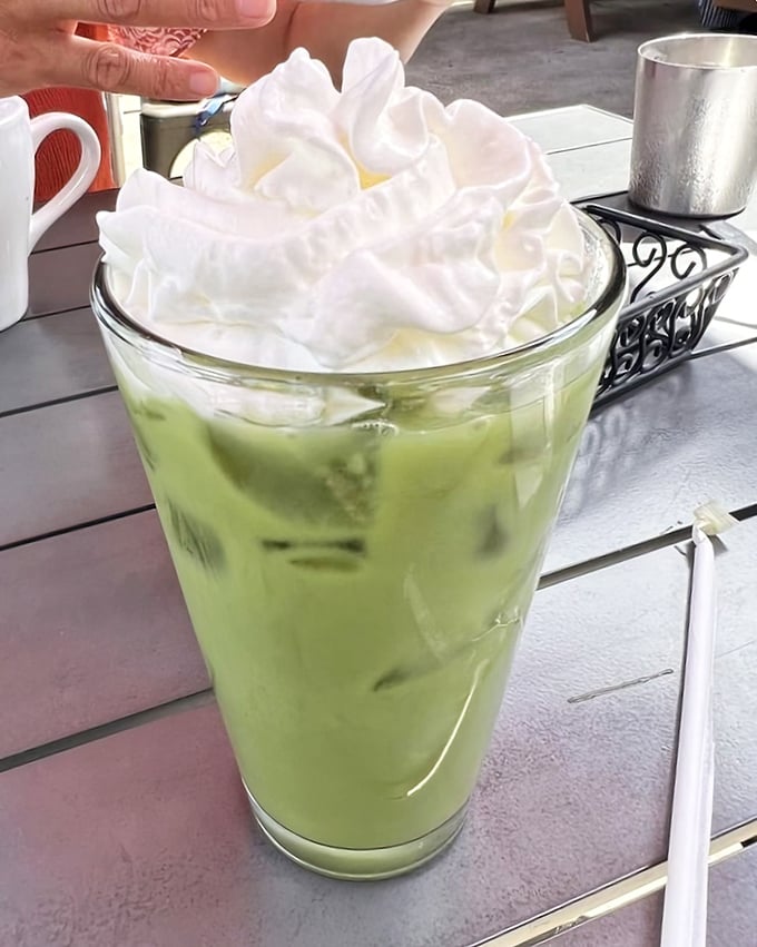 This isn't just a matcha drink—it's a tower of whipped cream atop a vibrant green sea of possibilities. Summer in a glass. 