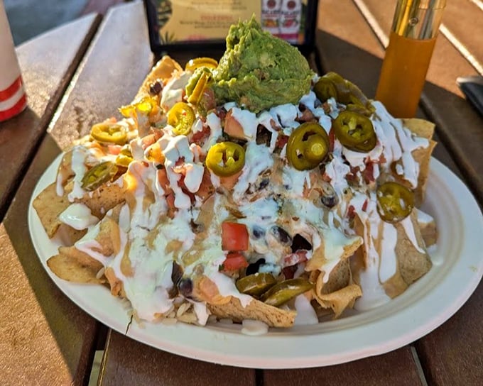 Nachos that require a strategy to eat—every chip a potential treasure chest of toppings. That guacamole crown deserves its own royal title.
