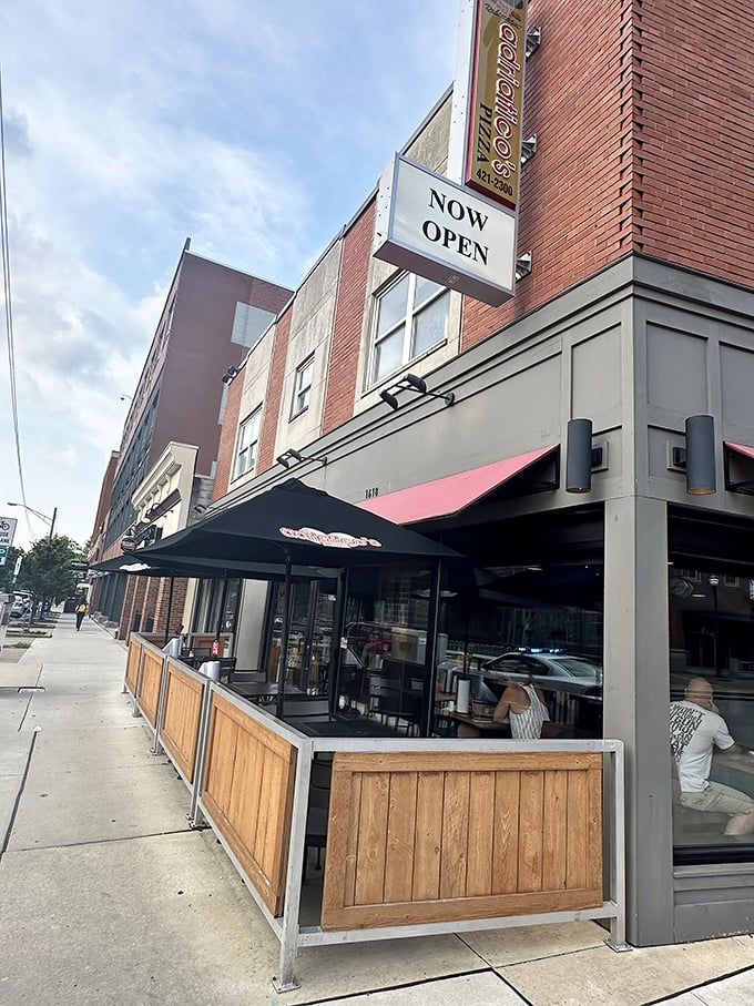 Outdoor seating that transforms sidewalk dining into an urban pizza picnic – fresh air somehow makes the cheese taste even better.