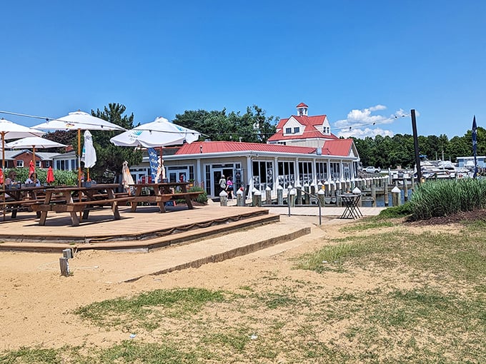 The restaurant's expansive outdoor area offers multiple ways to enjoy the bay – from sandy beach seating to covered deck dining for the sun-shy.