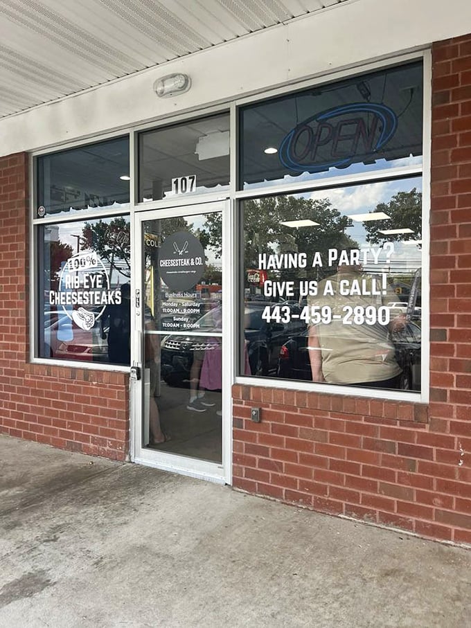 "Having a party? Give us a call!" promises the window sign—because nothing says celebration like a platter of Maryland's finest cheesesteaks.