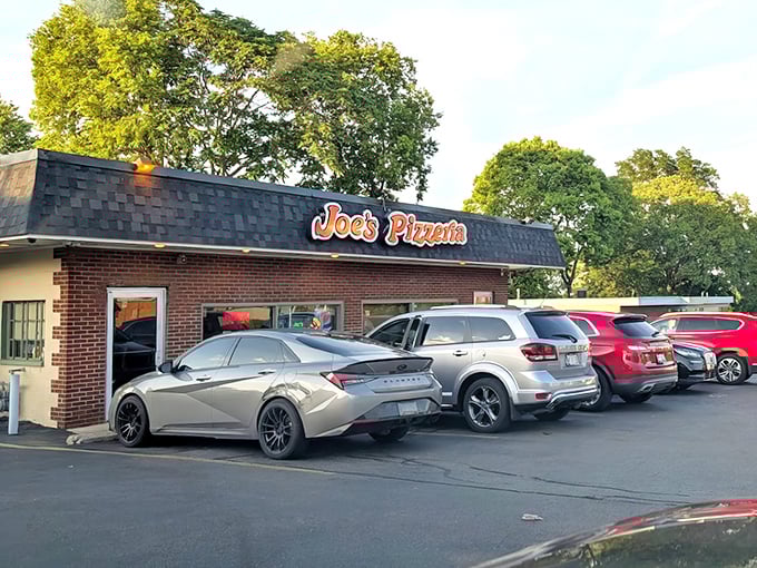 A packed parking lot tells the real story—when locals line up their cars outside a pizza joint, you know you've found the good stuff.