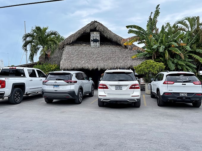 The parking lot tells the story—a mix of luxury SUVs and work trucks all drawn to the same thatched-roof temple of fresh Florida seafood.