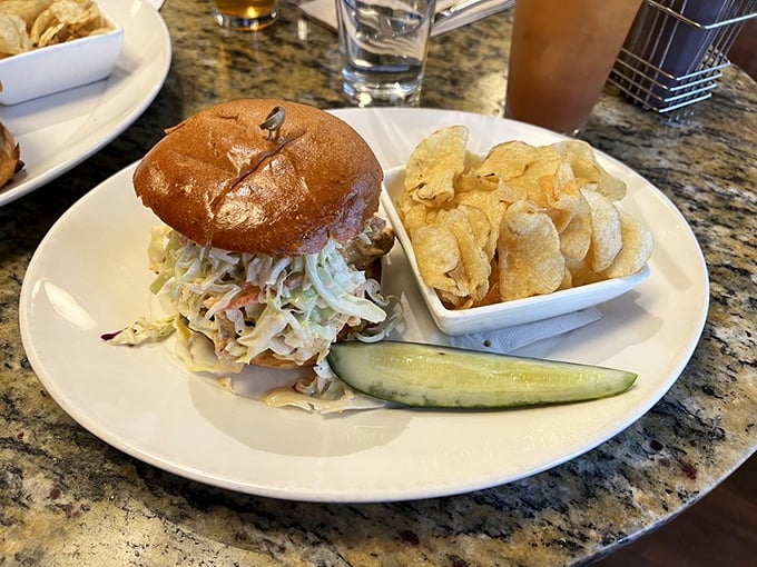 The pulled chicken sandwich arrives with perfect proportions of meat, slaw, and bun—a harmonious trio that sings in perfect barbecue harmony.