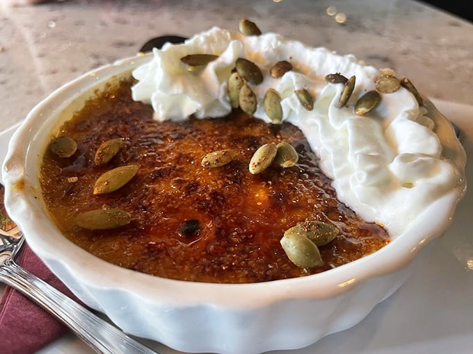 This crème brûlée isn't just dessert – it's a golden-topped treasure chest with a perfectly crackable surface that satisfies your inner child and sophisticated adult simultaneously.