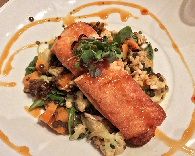 Perfectly seared fish with artistic sauce swirls – proof that some plates deserve to be in both your stomach and an art gallery.