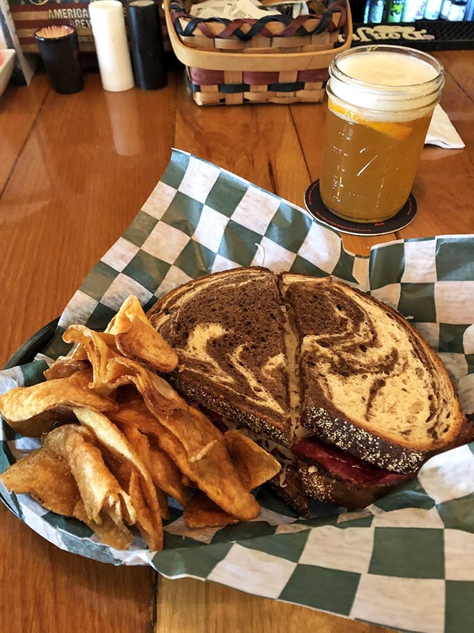 This marbled rye sandwich with house-made chips isn't just lunch – it's edible architecture. The golden beer alongside completes this midday masterpiece.
