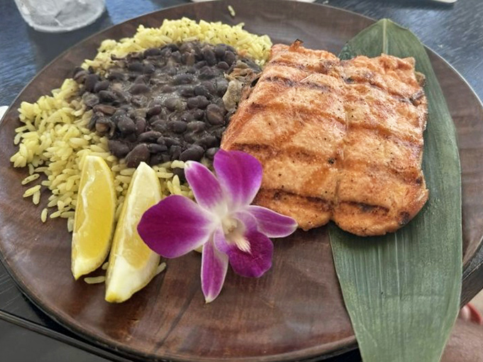 Grilled salmon perfection accompanied by sides that complement rather than compete – culinary teamwork at its finest level.
