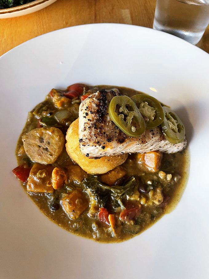 This seabass dish is a study in textures—crispy skin, tender flesh, and a broth that begs to be sopped up with anything within reach.
