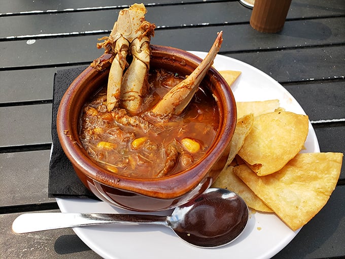 A hearty crab soup that could warm the coldest day, with crab legs dramatically reaching skyward like they're still telling sea stories.