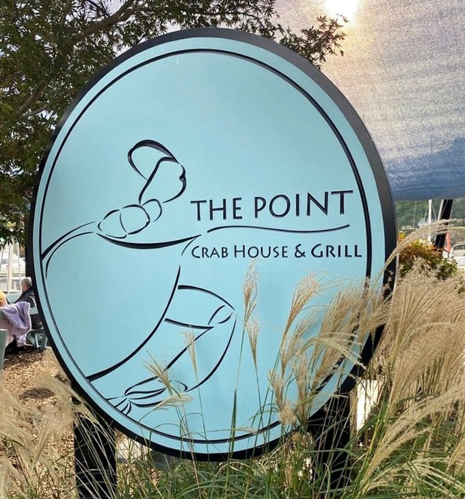The sign says it all – a crab silhouette promising seafood salvation. Those waving grasses are nature's way of pointing you toward dinner.