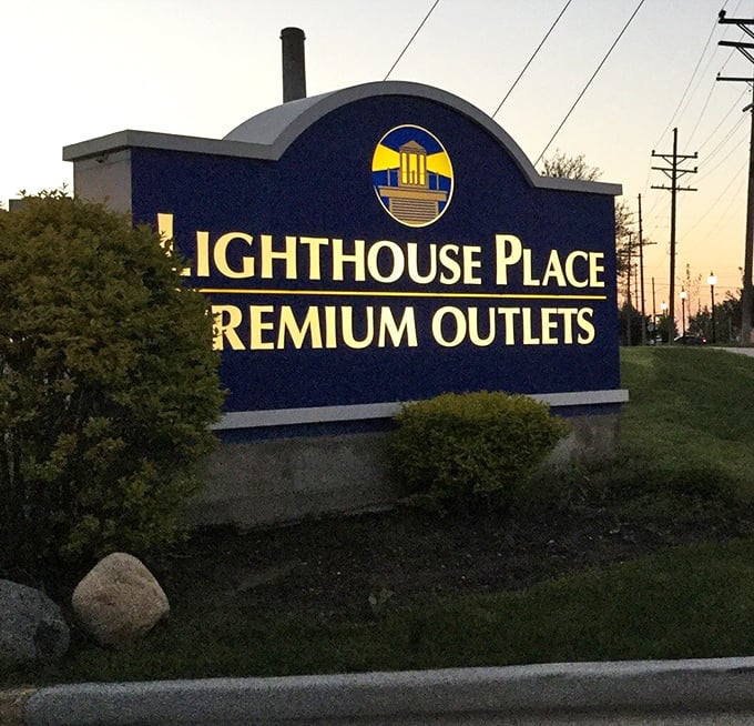The entrance sign glows at dusk, beckoning shoppers like moths to a flame—a very fiscally responsible flame.