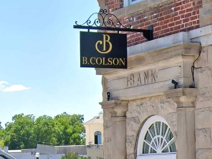 The elegant B. Colson sign hangs proudly against historic architecture, a modern culinary beacon in Camden's charming downtown landscape.