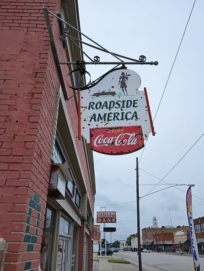 The weathered sign swings gently above Hillsboro's main street, a beacon for travelers seeking America's roadside soul in the heart of Texas.