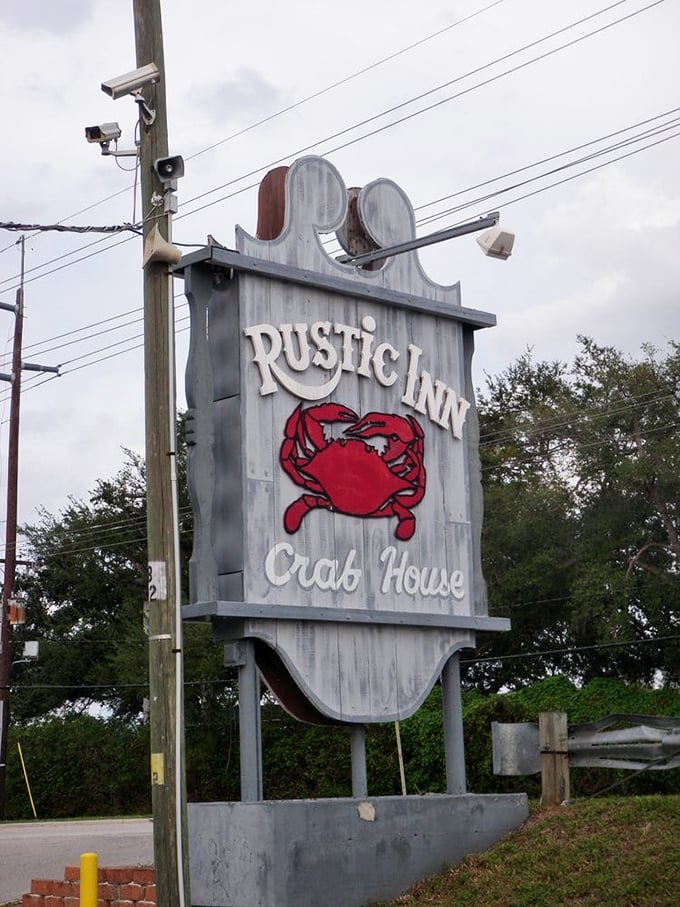 The roadside sign stands like a beacon to hungry travelers—that red crab silhouette promising seafood salvation just around the corner.