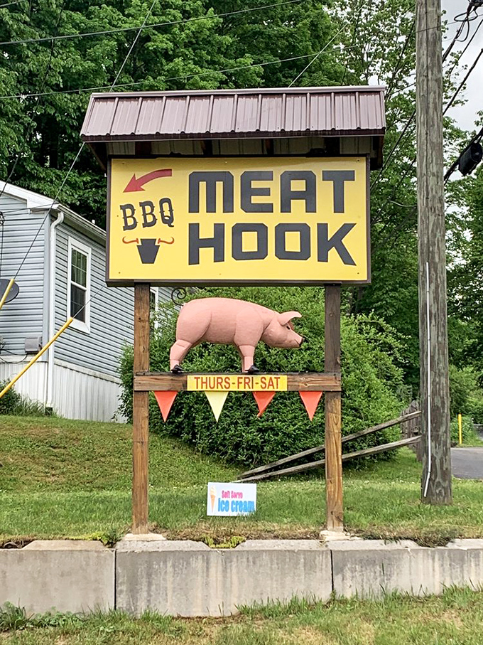 The roadside sign with its pink pig sentinel stands as a beacon of hope for travelers with empty stomachs and barbecue dreams.